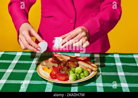 Woman cooking fried eggs, English breakfast on plate on green ...