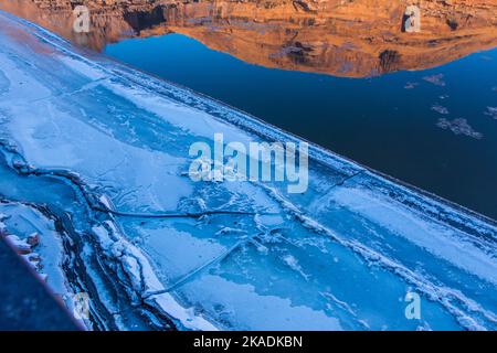 Orange sandstone cliffs reflected on the surface of the Colorado River ...