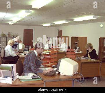 1989, historical, male and female employees working at their desks in ...