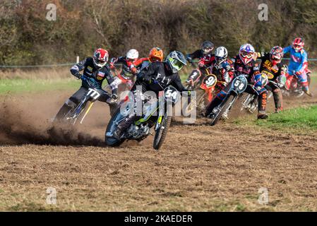 GT140 solo class riders racing in a grasstrack motorcycle race. Donut ...