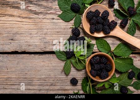 Ripe juicy blackberries with wooden spoon and small glass bowl Stock ...