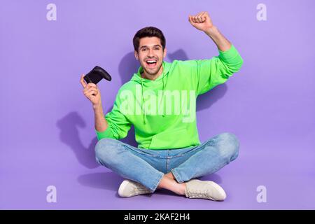 Full length photo of excited lucky man wear green t-shirt rising fists ...