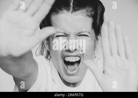 The girl screams and covers her face with her hands isolated background ...
