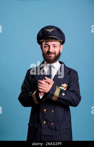 Smiling excited plane aviator in professional uniform clapping hands ...
