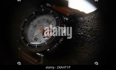 Wrist watch with water particles on it with blurry look extreme close ...