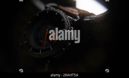 Wrist watch with water particles on it with blurry look extreme close ...