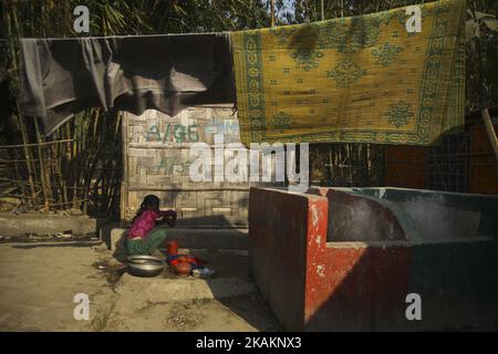 Rohingya refugee, in Bangladesh, washing their clothes in a rice field ...