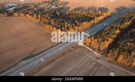 Aerial view of intercity road with fast driving cars between autumn ...