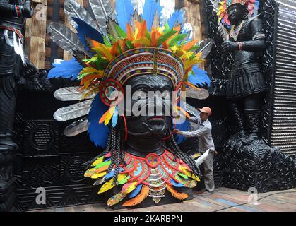 An Indian artisan prepares the statue of Red Indians in a Puja pandal ...