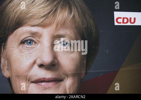A vandalized election poster showing German Chancellor Angela Merkel ...