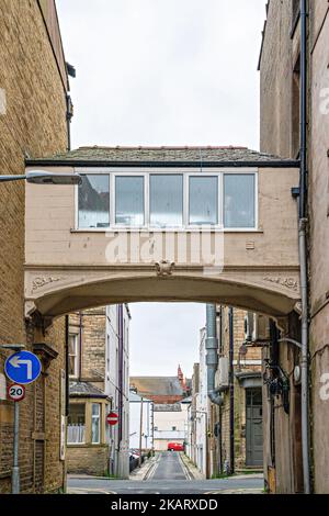 A narrow alleyway between two buildings with a small balcony featuring ...