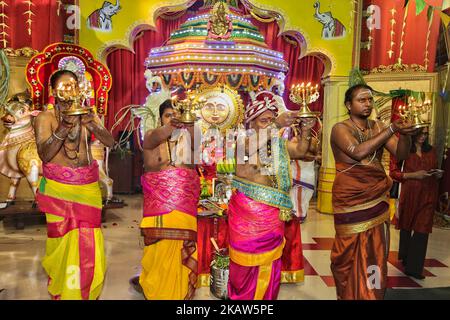 Tamil Hindu priests perform special prays as they bathe a large stone ...