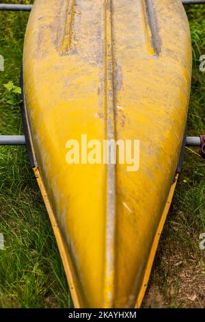 Yellow canoe lying upside down Stock Photo - Alamy