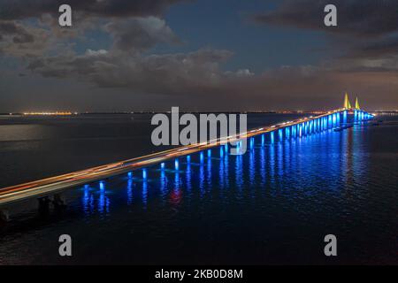 Aerial night panorama of Sunshine Skyway Bridge illuminated above Tampa ...