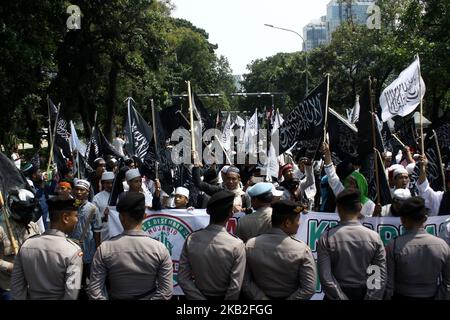 Indonesian Muslims carrying Tawheed flags and other attributes staged ...