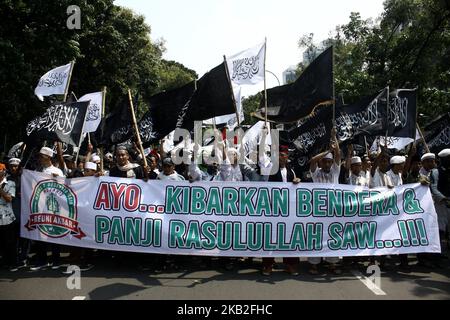 Indonesian Muslims carrying Tawheed flags and other attributes staged ...
