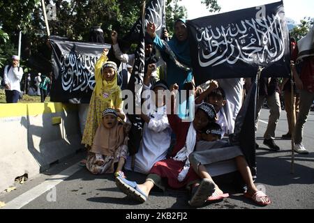Indonesian Muslims carrying Tawheed flags and other attributes staged ...