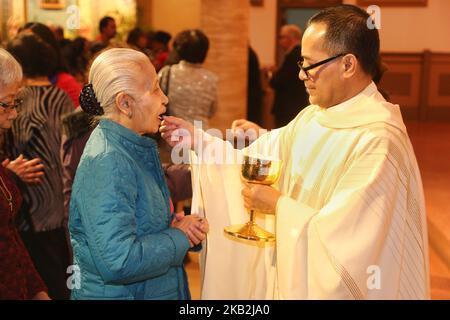 Filipino Catholic priest performs communion during a special mass ...