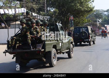 Bangladeshi army personnel drive a military vehicle through a street ...