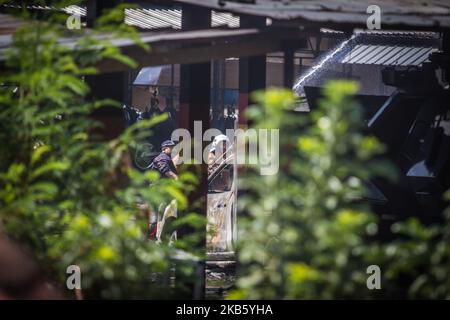 A rescue worker puts out a fire of a house destroyed after a Russian ...
