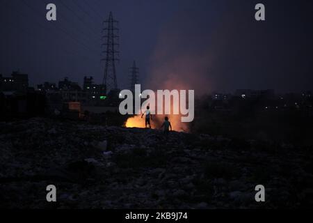Children seen working as toxic garbage are buring in a dumping area ...