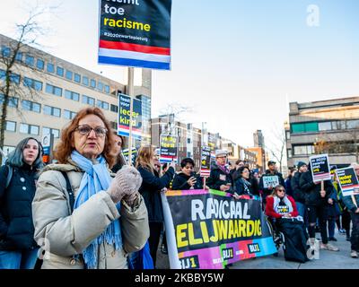 People are holding placards and shouting slogans in front of the ICJ to ...