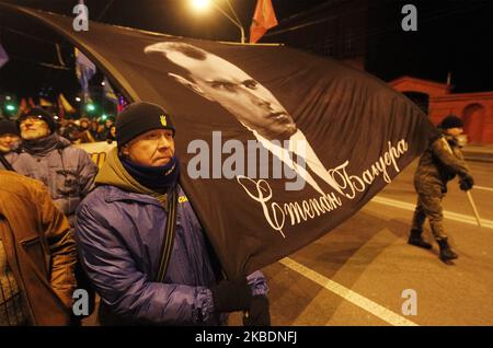 Ukrainians carry a banner with Stepan Bandera portrait during a ...