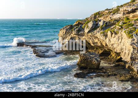 Scenic view of Waenhuiskrans sea-cave and rugged rocky shoreline at ...