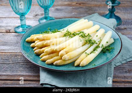 Modern style traditional steamed white asparagus garnished with butter ...