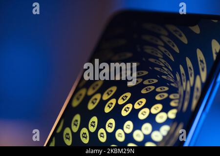 Bitcoin logos are seen on an iPhone 11 Pro Max in this illustration ...