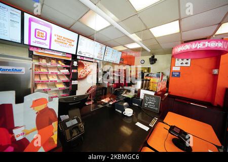 A view of a Dunkin' Donuts cashier protected by a plastic partition as ...