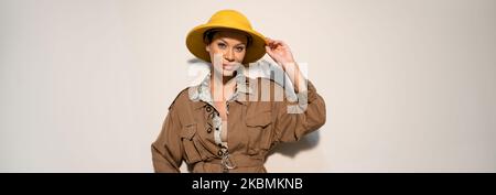 cheerful archaeologist in brown jacket and makeup smiling at camera on ...
