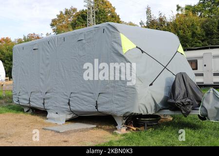 a caravan with a gray tarpaulin Stock Photo - Alamy