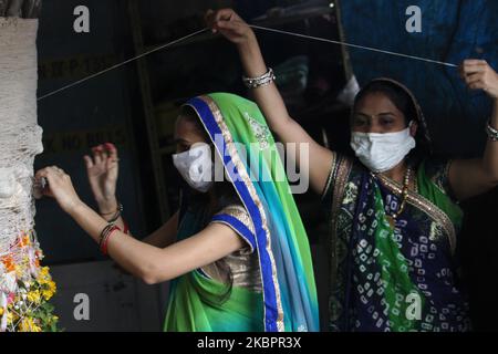 Married women tie thread around a Banyan tree as part of rituals to ...
