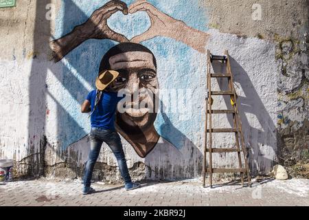A Palestinian artist Ayman Al-hossary paints a mural that depicts ...