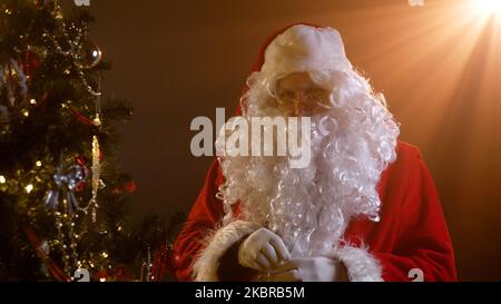Fat man in glasses dressed as Santa holds tangerines on the ocean Stock ...