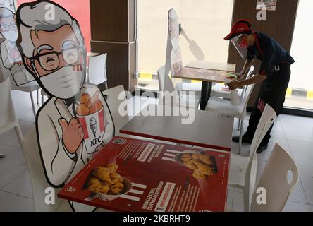 Waiters tidy up tables and draw KFC (Kentucky Fried Chicken) characters ...