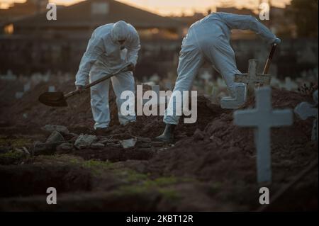 Agents of the funeral service (gravediggers) using personal protective ...