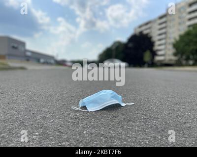 A discarded protective face mask is seen on the ground amid the COVID ...