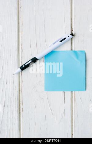 Blue sticker and pen over a white surface Stock Photo - Alamy