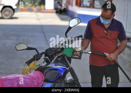 An employee at a fuel station fills a bike with Petrol in Sopore town of District Baramulla ...