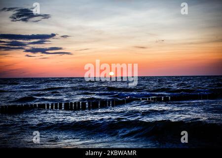 The sun rises over the pier at the Baltic Sea in Timmendorfer Strand ...