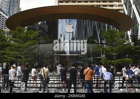 Customers stand in line outside the new Apple store at the shopping ...