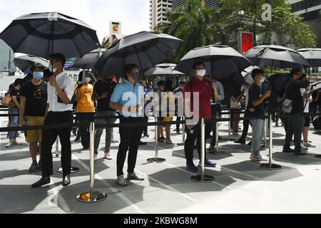 Customers stand in line outside the new Apple store at the shopping ...