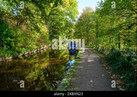 A tranquil scene of a narrowboat moored beneath trees on the Llangollen ...