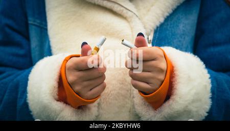 Crop woman breaking cigarette and quitting smoking. Closeup of crop ...