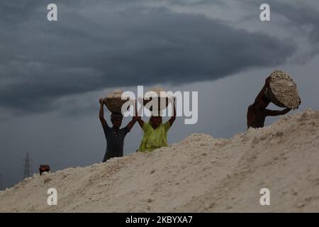 Labors carry sand as they unload from a ship in Dhaka, Bangladesh on ...