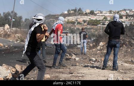 Palestinians throw stones at Israeli military vehicles during clashes ...