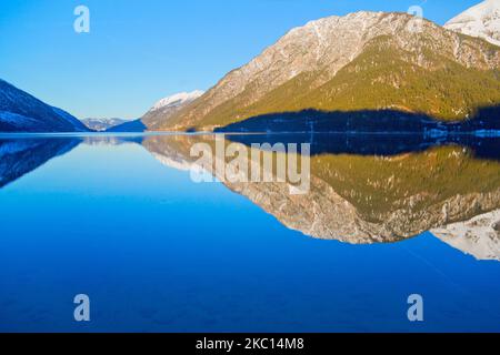 Achensee Lake in winter, Pertisau and the Karwendel mountains at back ...