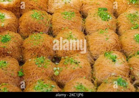 Rows of Sweet Turkish dessert kunefe with pistachio powder, Kataifi ...